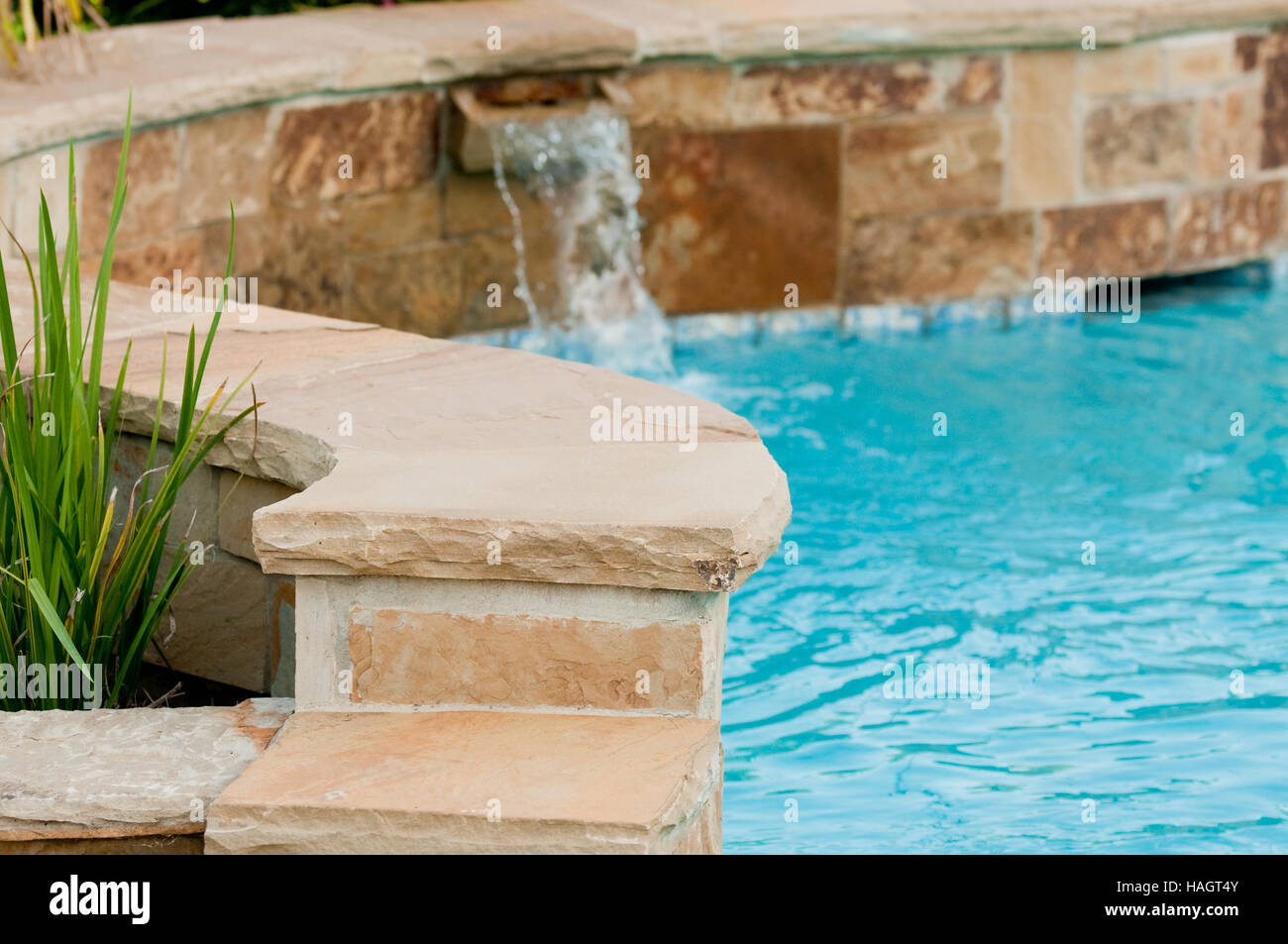 Beautiful swimming pool with flagstone wall that has waterfall pouring ...