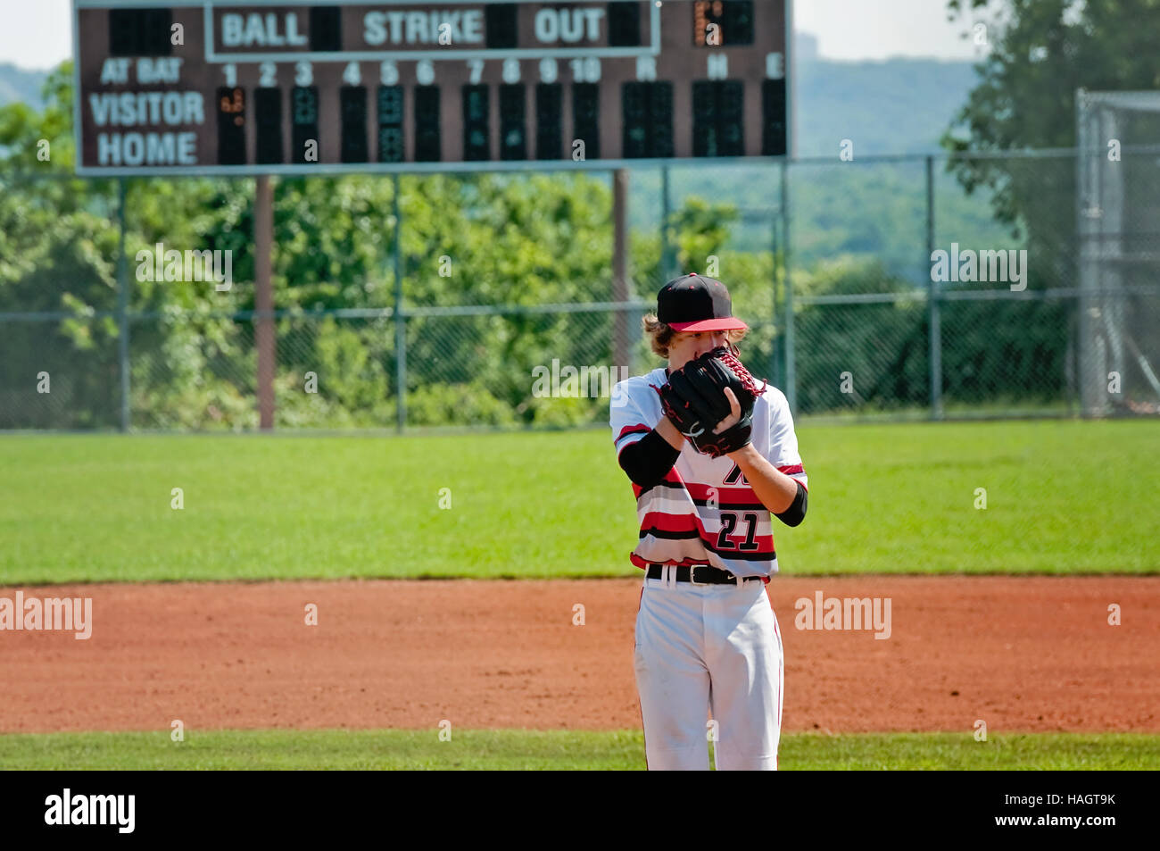 American teenage baseball pitcher being focused on the mound during the ...