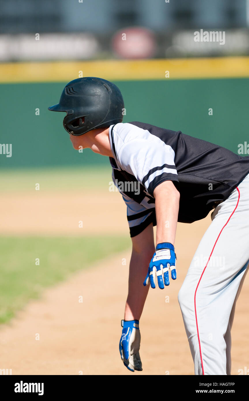 High school baseball boy standing on first base ready to steal Stock ...