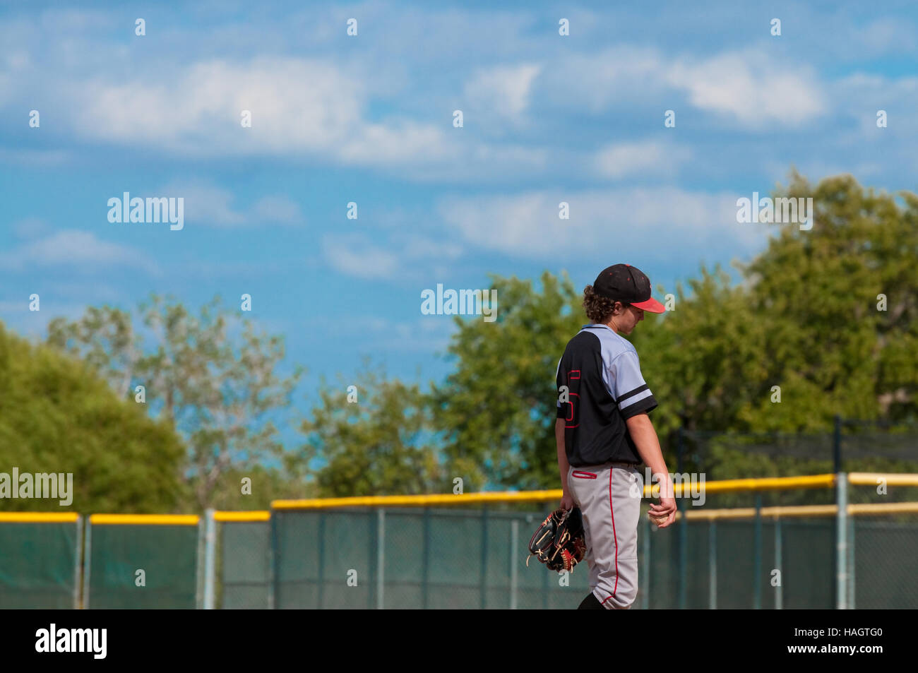 Baseball pitcher in black and grey jersey looking sad during a game ...