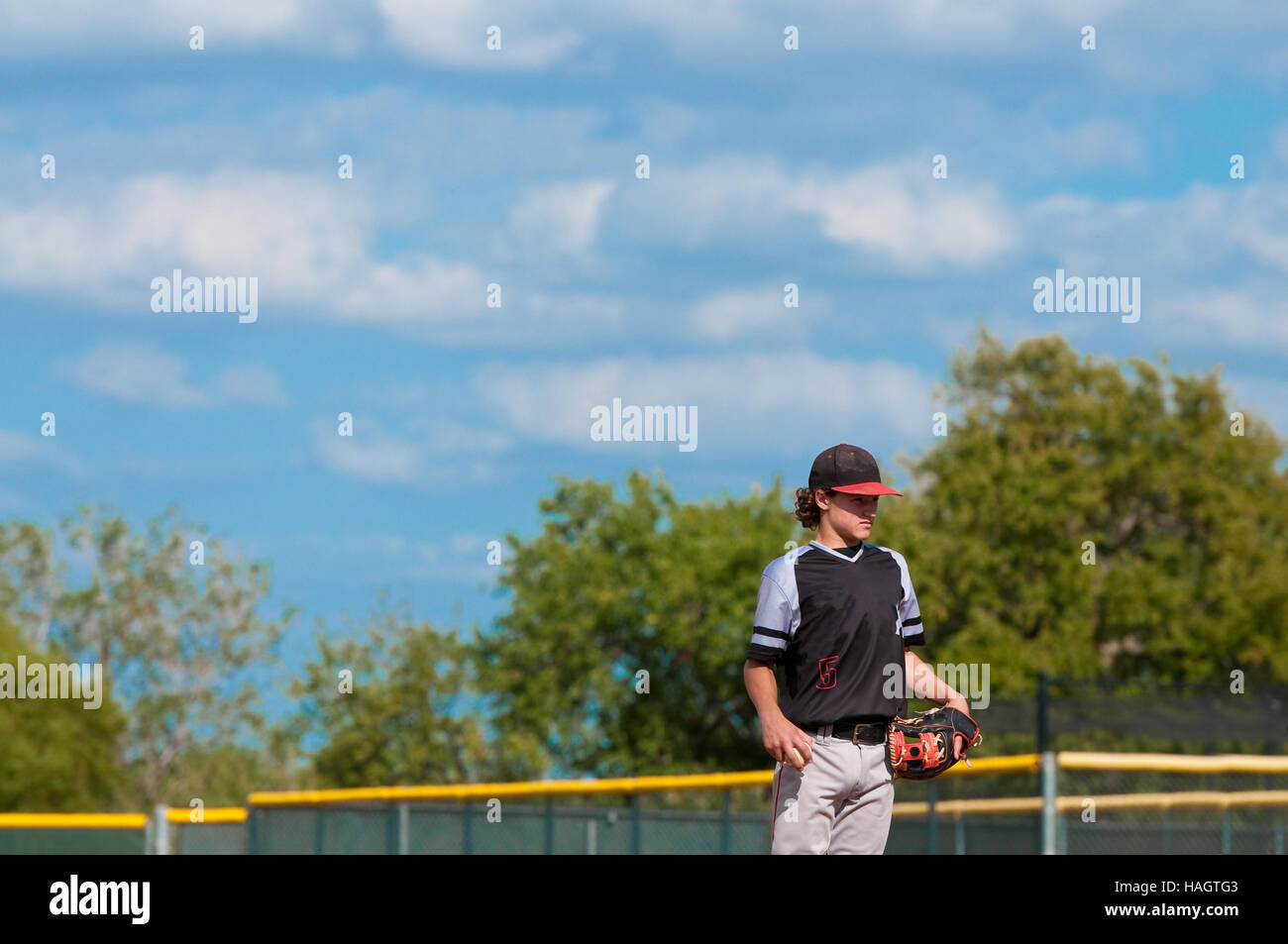 Baseball pitcher in black and grey jersey looking at catcher during a ...