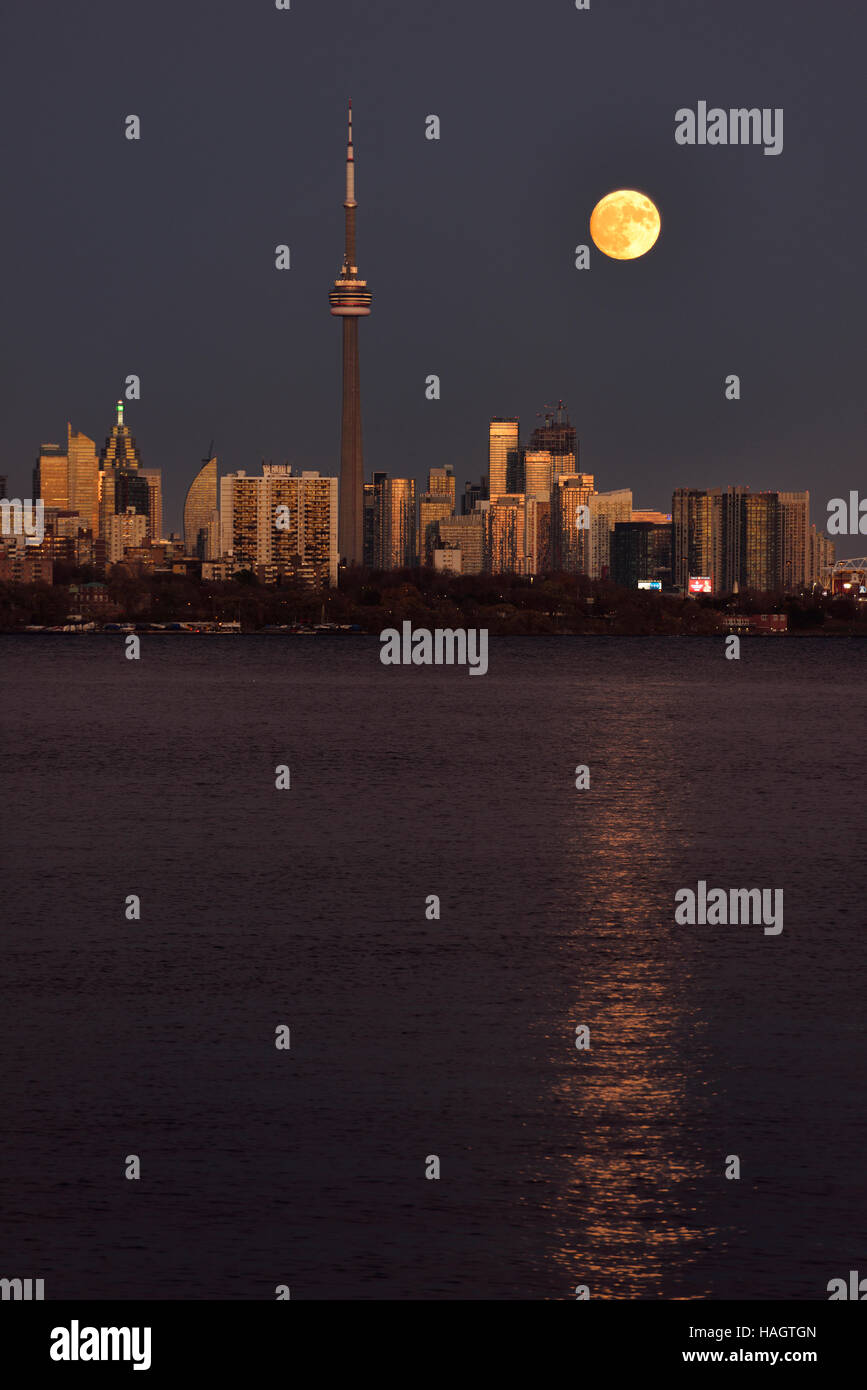 Red supermoon reflected in Lake Ontario rising over Toronto cityscape ...