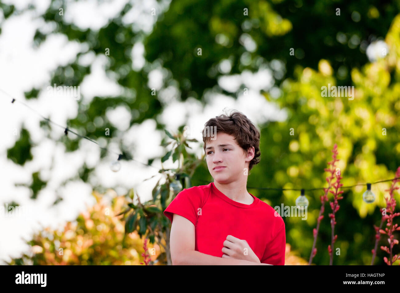 Handsome teenage boy outside looking sideways with blank expression on ...
