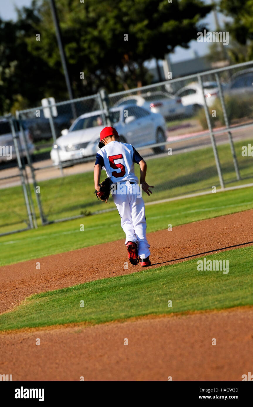 Rear view of baseball player walking across field during game Stock ...