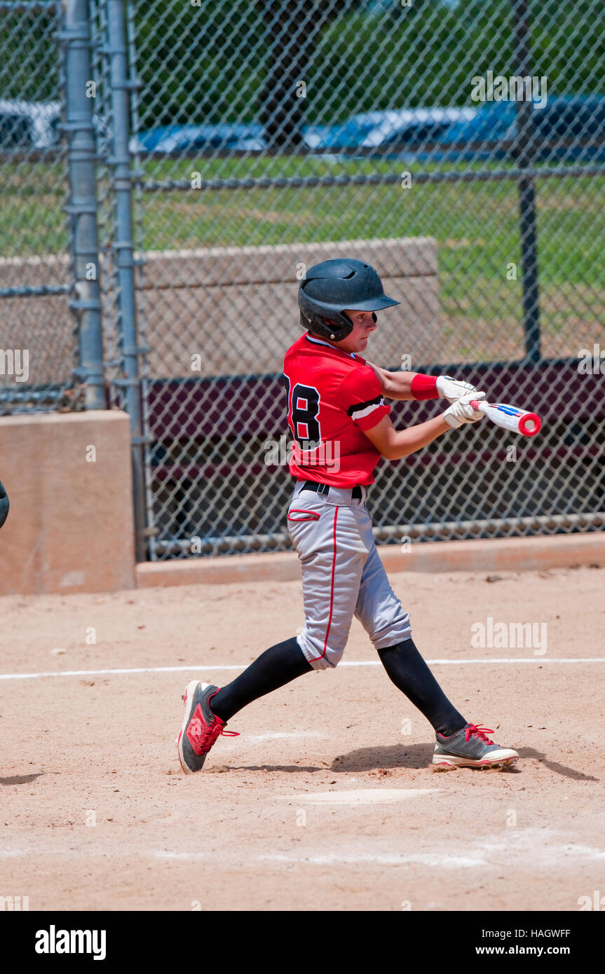 Youth baseball player batting the ball during a game Stock Photo - Alamy