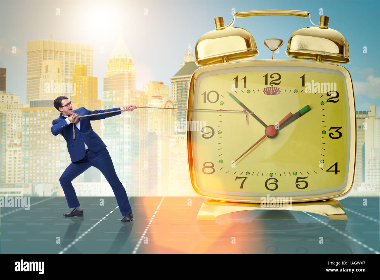 Businessman pulling clock in time management concept Stock Photo - Alamy