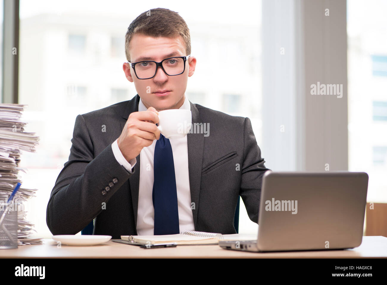 Young businessman drinking tea in the office Stock Photo - Alamy