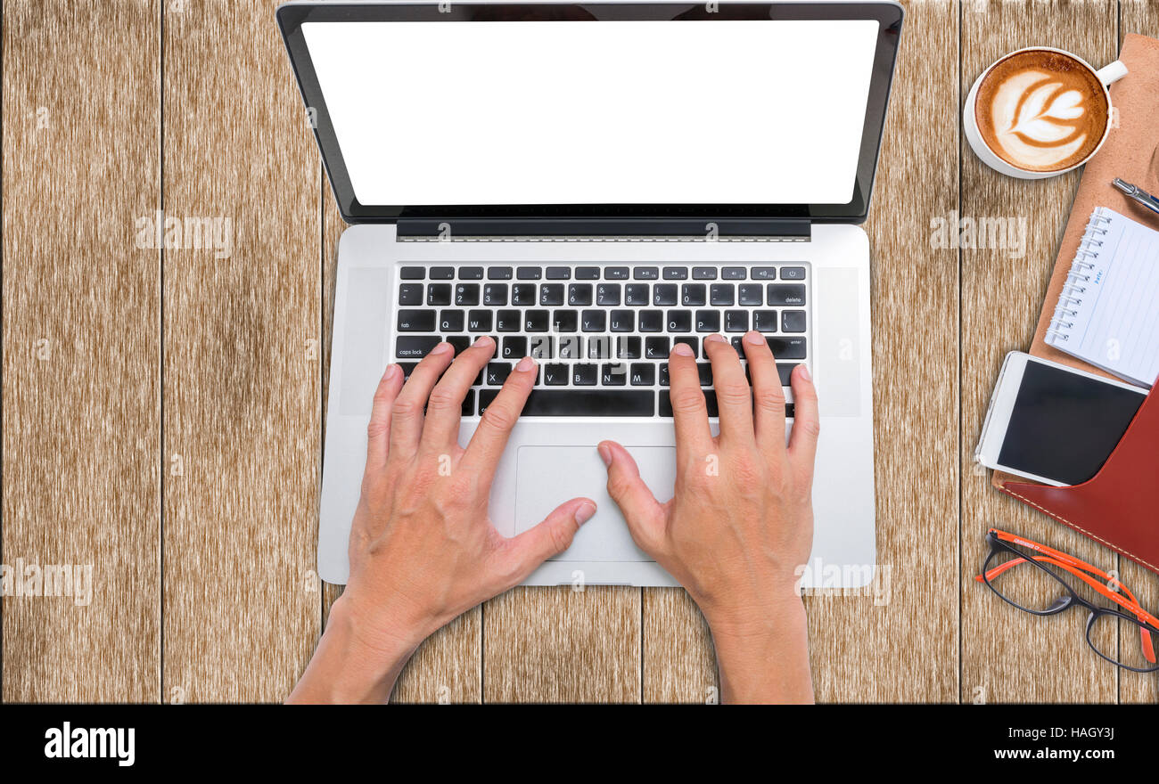 top view of hand typing laptop with blank screen ,sitting at wooden ...