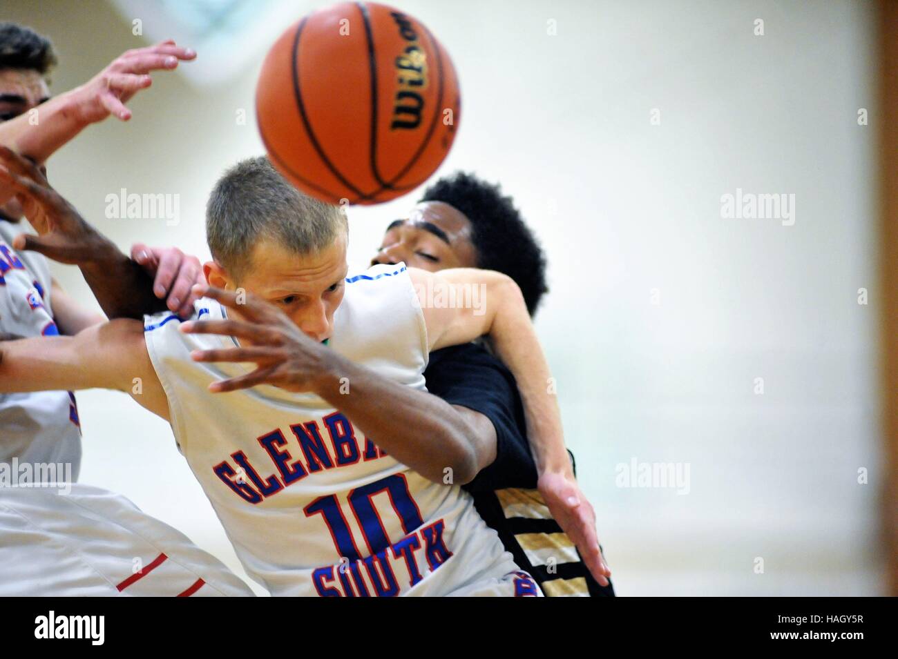 Players battle for a loose ball in the paint during a high school ...