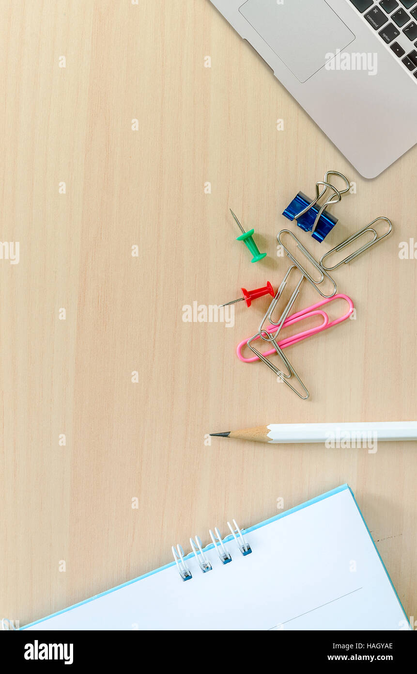 top view of desktop work with laptop,pencil,paper clips and notebook ...