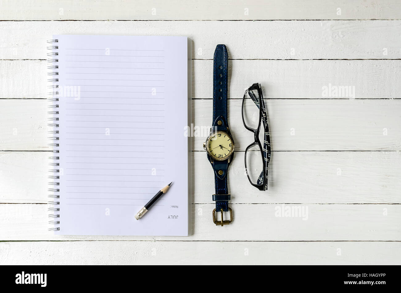 Blank note book , pencil ,watch and eyes glass on wooden background ...