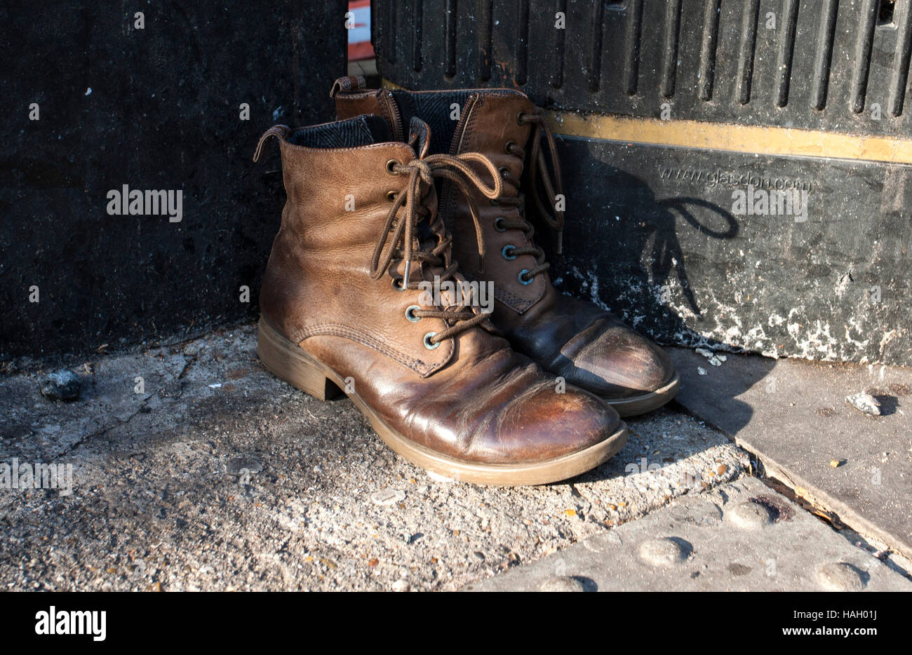 An old pair of abandoned brown boots dumped by a rubbish bin in Brick ...