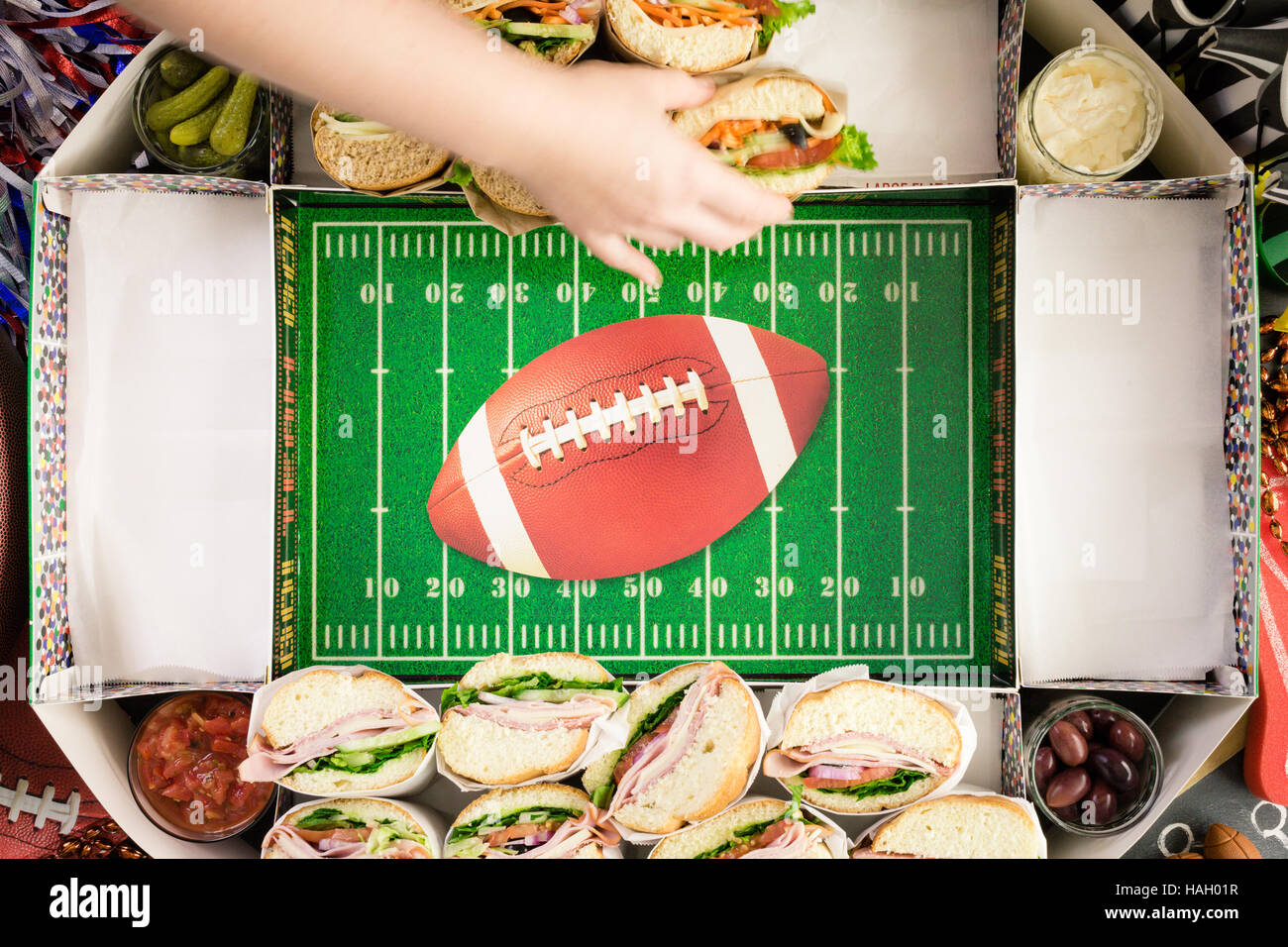 Step by step. Filling in football snack stadium with sub sandwiches ...