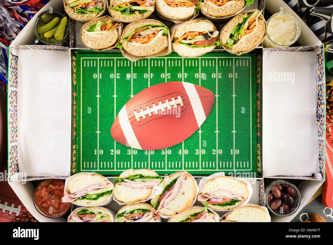 Step by step. Filling in football snack stadium with sub sandwiches ...