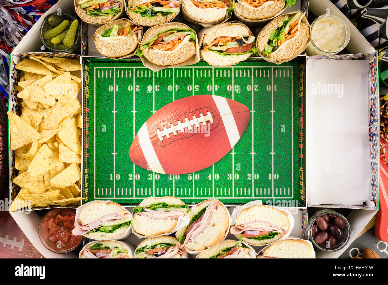 Step by step. Filling in football snack stadium with sub sandwiches ...