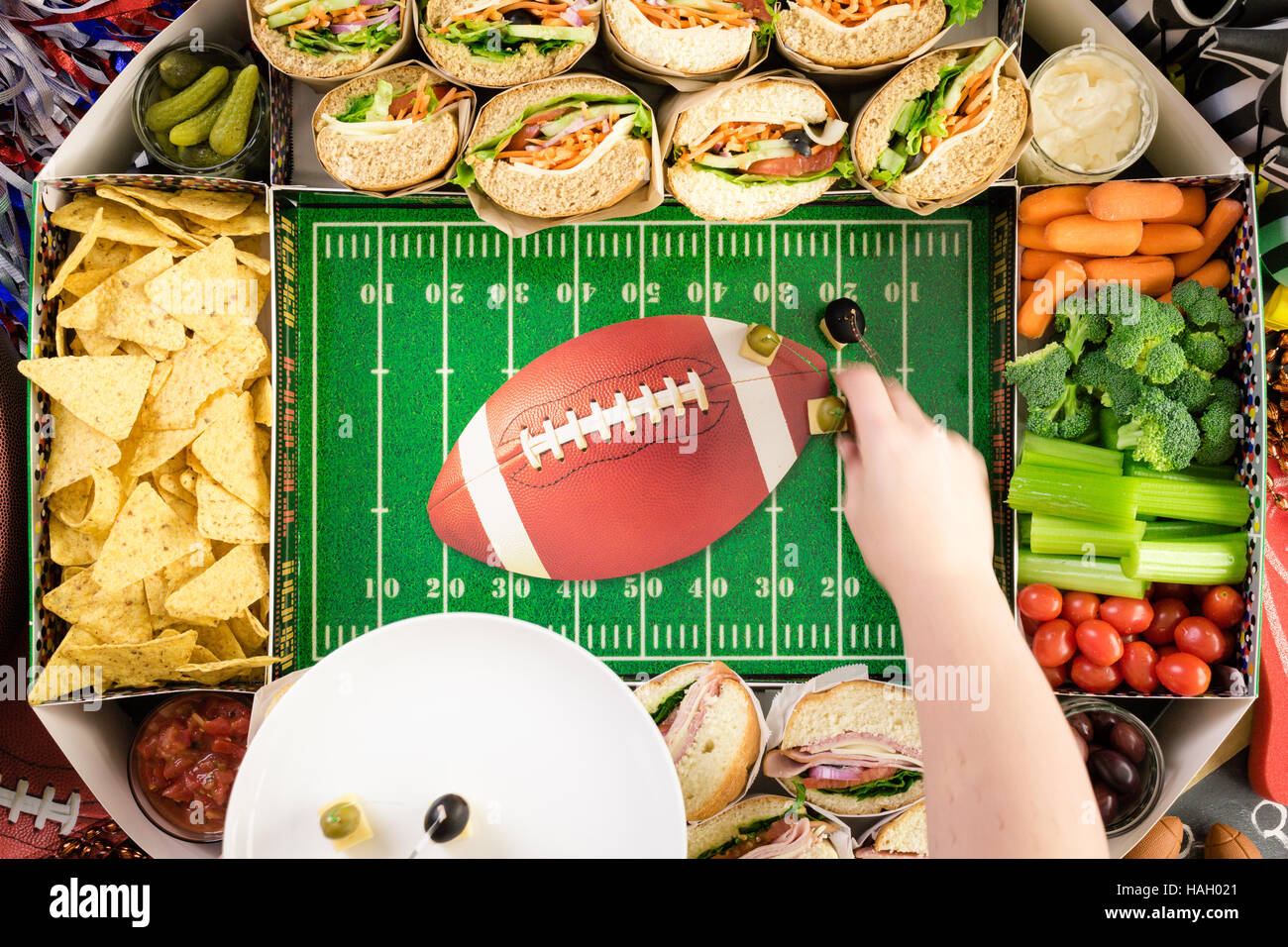 Step by step. Filling in football snack stadium with sub sandwiches ...