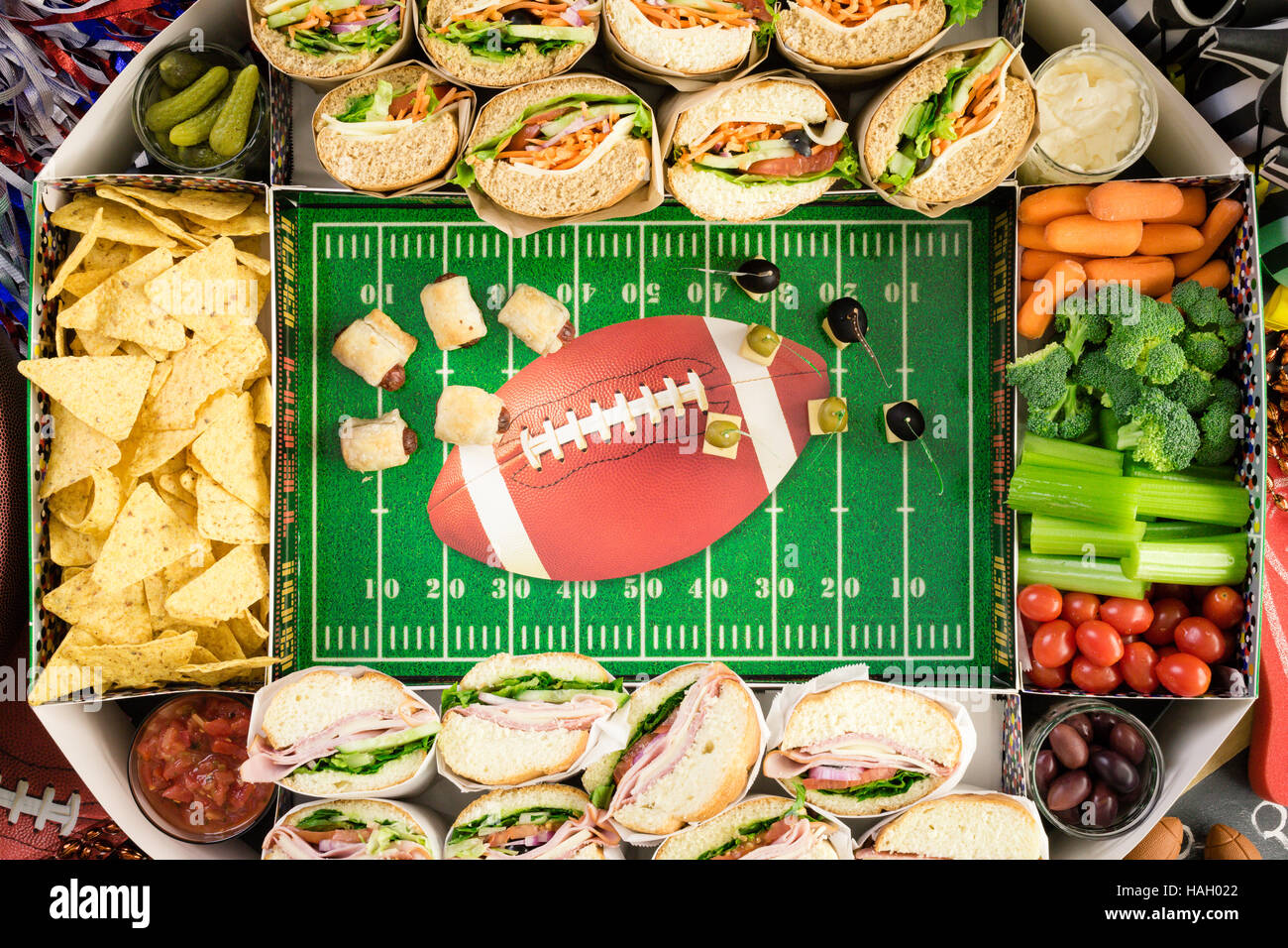 Step by step. Filling in football snack stadium with sub sandwiches ...