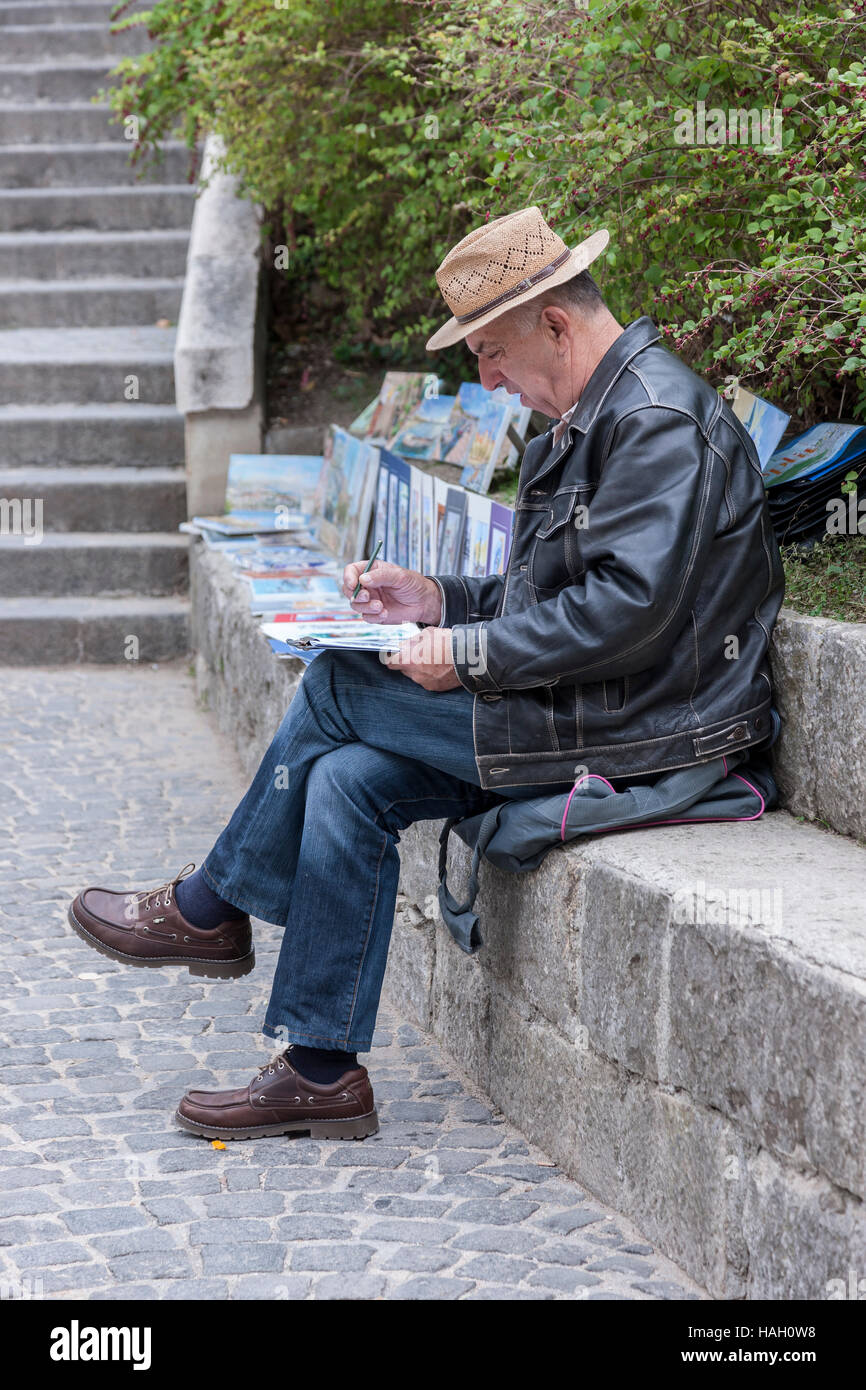 Male artist sat on a stone wall working, Split, Croatia Stock Photo - Alamy