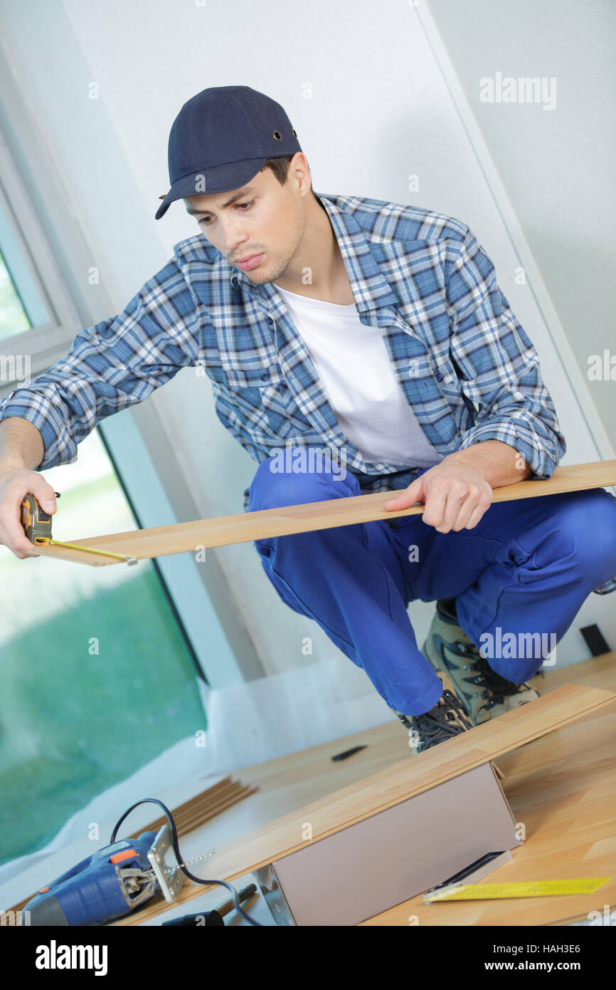 young technician installing floor at construction site Stock Photo - Alamy