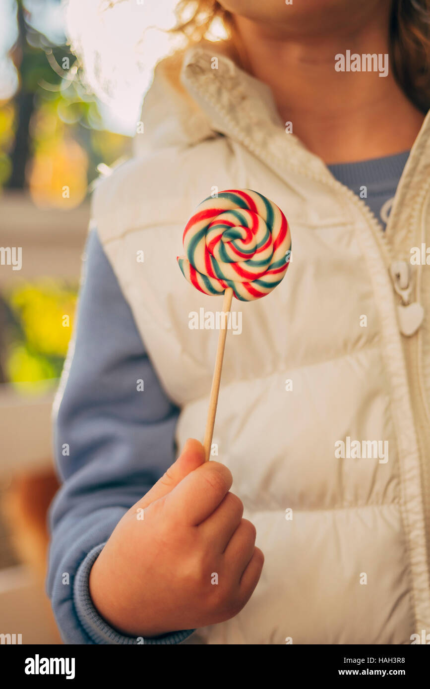 Lollipop in girl's hands Stock Photo - Alamy