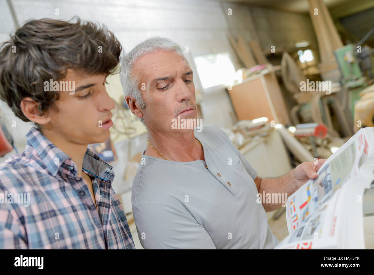 Carpenter stood with young apprentice Stock Photo - Alamy