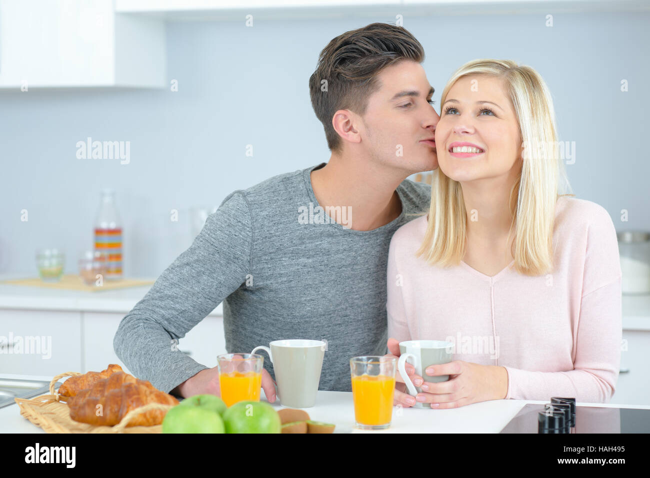 Man kissing lady at breakfast table Stock Photo - Alamy