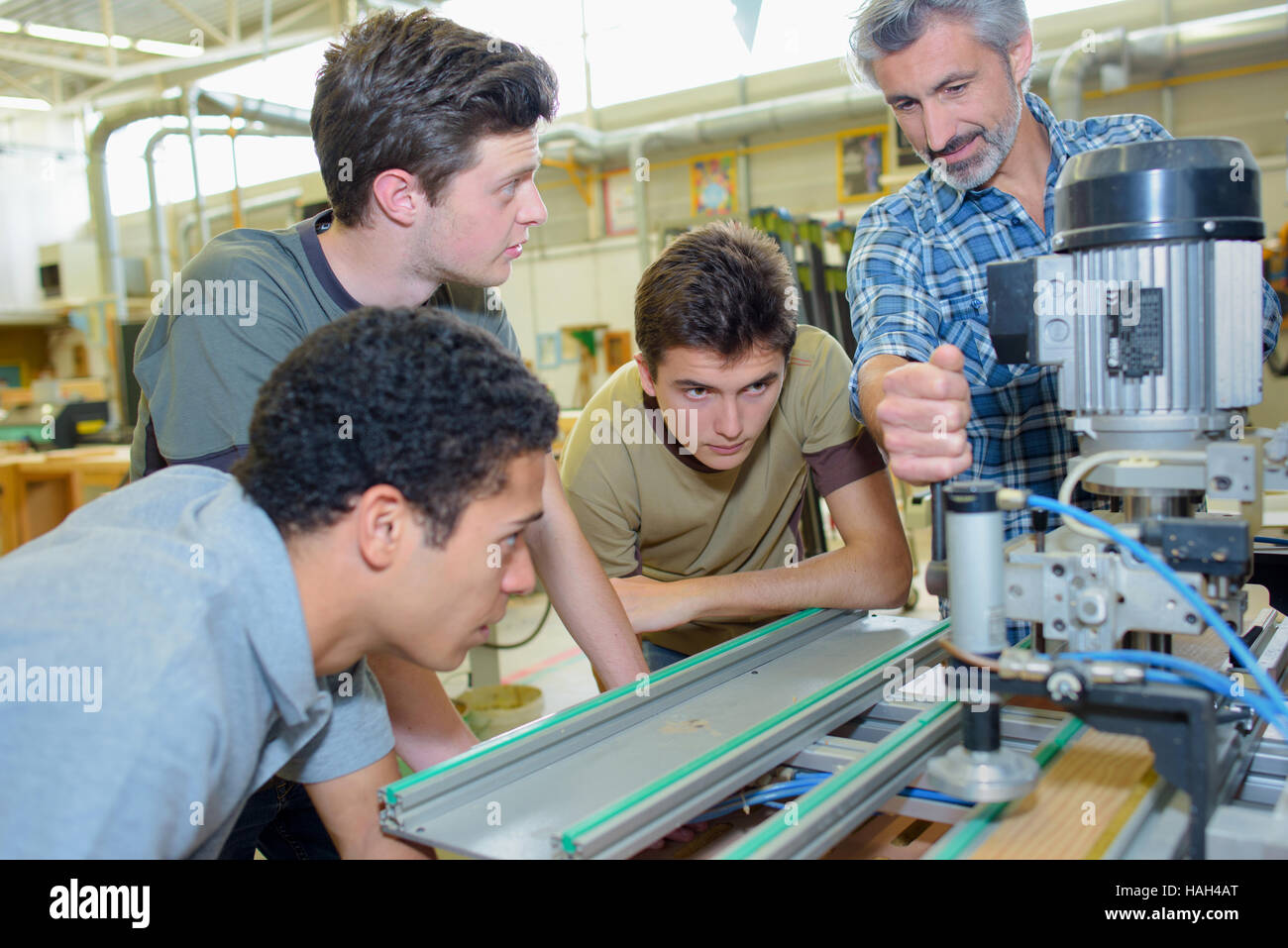 Apprentices learning to use machine Stock Photo - Alamy