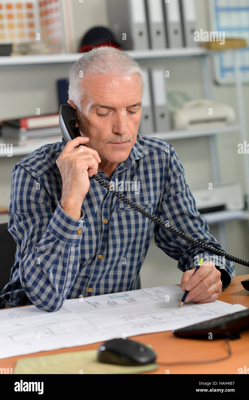 Senior man taking a call at his desk Stock Photo - Alamy