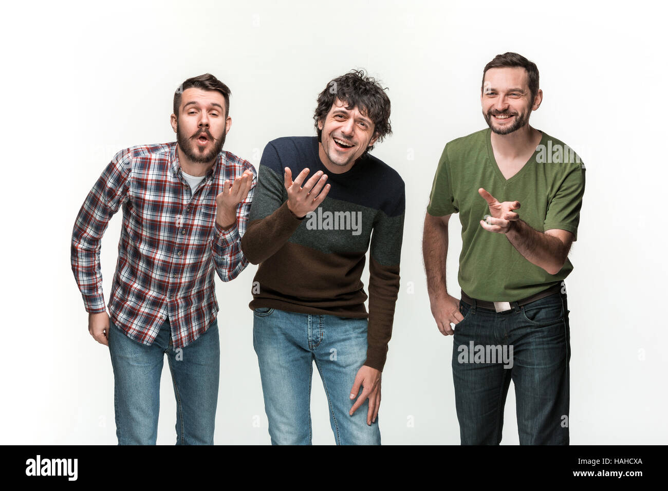 The three men are smiling, looking at camera Stock Photo - Alamy