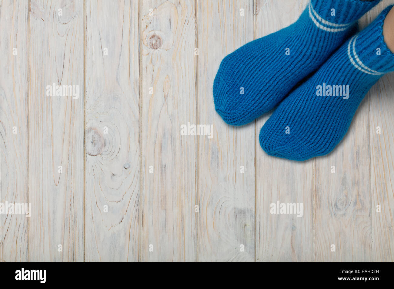 Female feet in knitted blue socks on white wooden background Stock ...