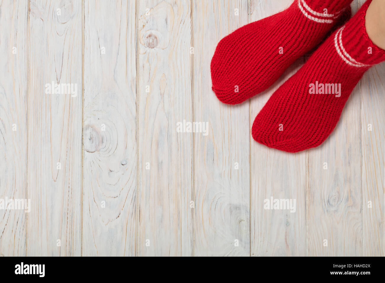 Female feet in knitted red socks on white wooden background Stock Photo ...