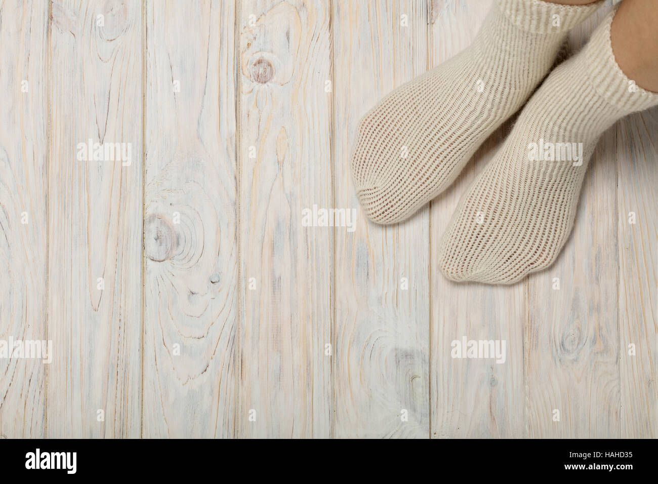 Female feet in knitted white socks on white wooden background Stock Photo - Alamy