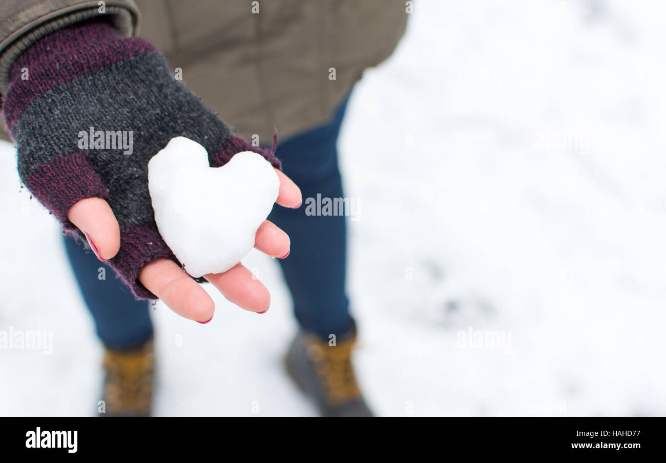 Woman hands holding heart shaped snowball outdoors Stock Photo - Alamy