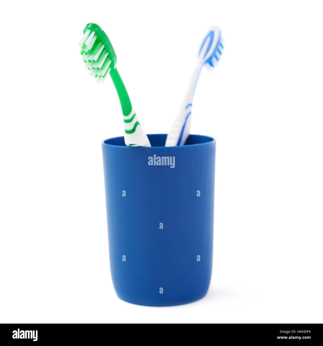 Pair of toothbrushes in blue plastic cup isolated over white background ...