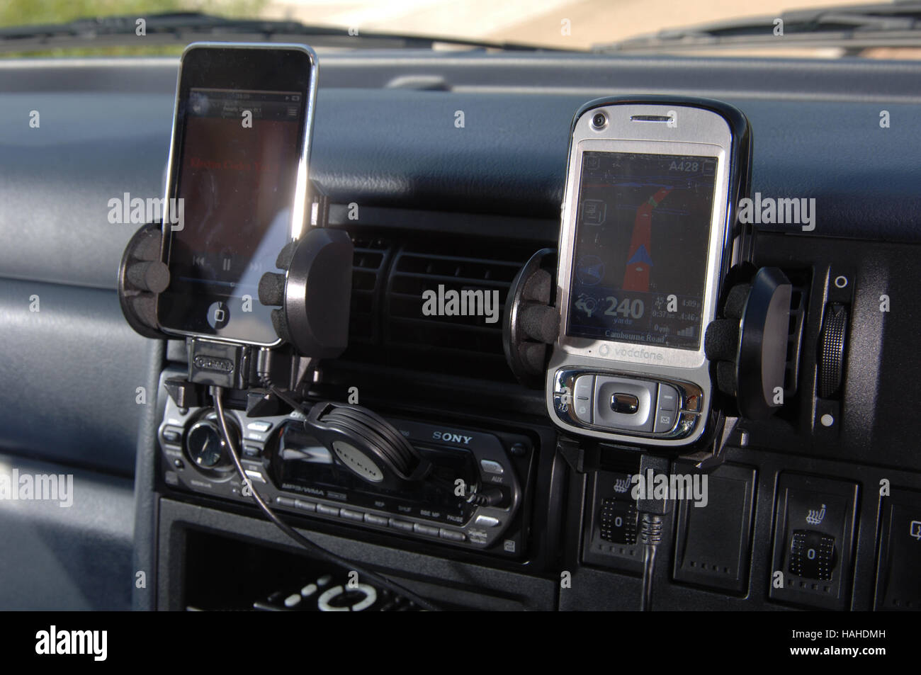 mobile technology, mobile phone with sat nav and iPhone in holders on ...