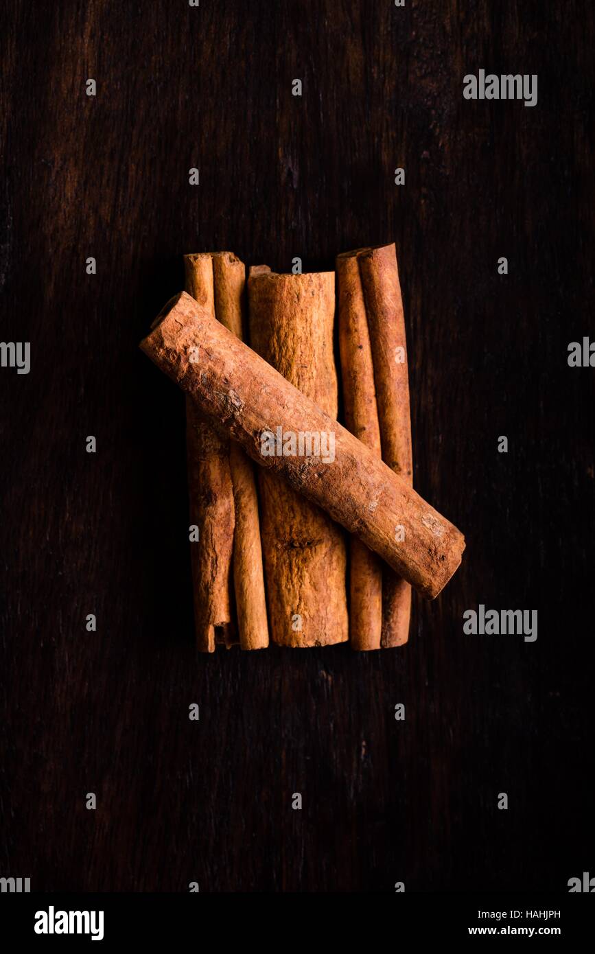 Vertical photo with top view on four pieces of cinnamon spice which is ...