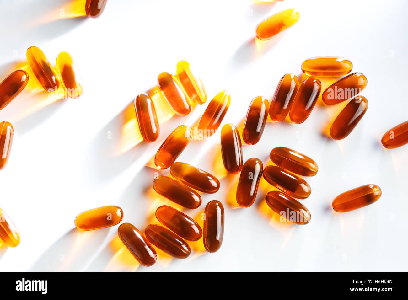 Gel capsules scattered on white background, health treatment concept ...