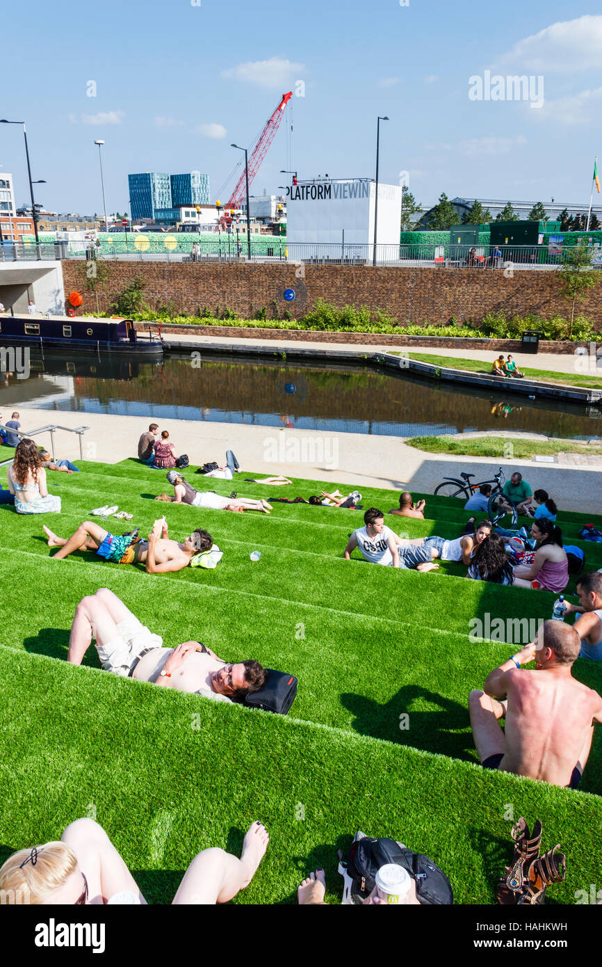 Sunbathers on the artificial-grassed steps of Granary Square by Regent ...