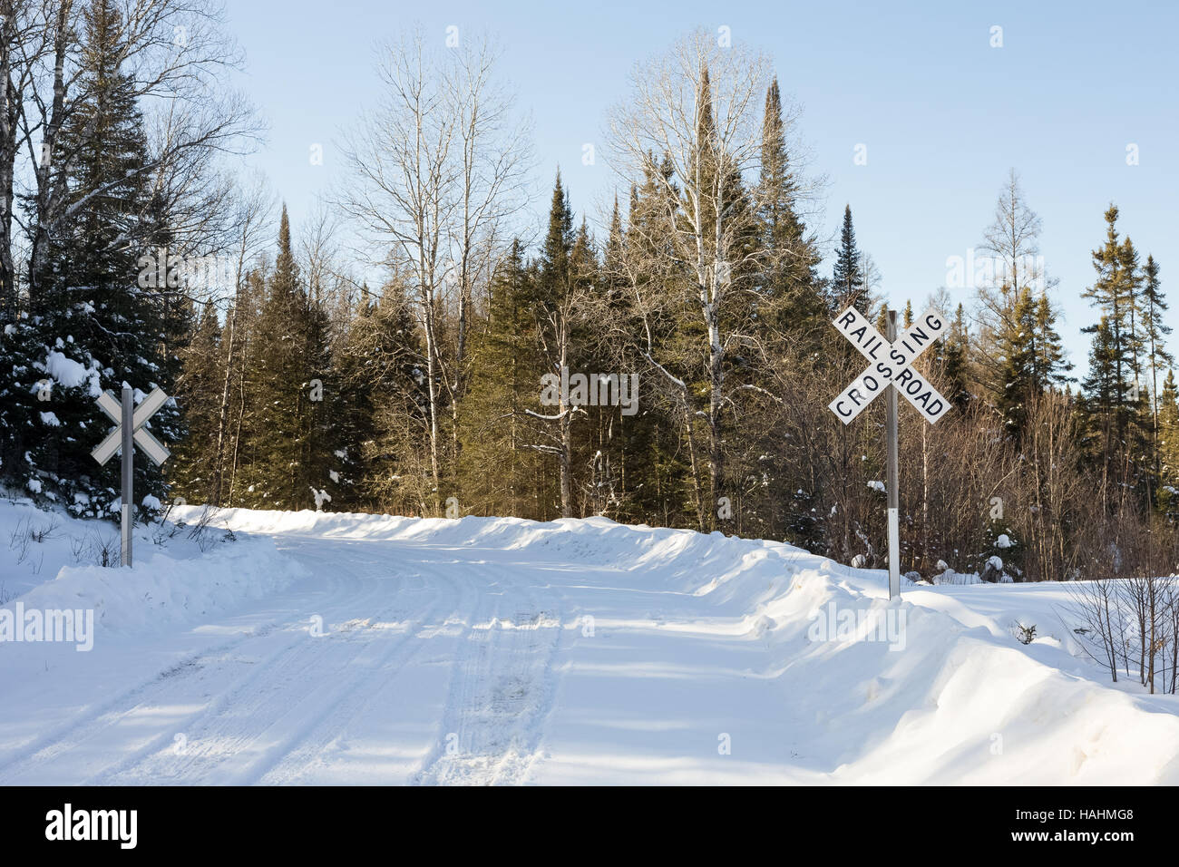 Railroad crossing along a snow covered rural road in winter Stock Photo ...