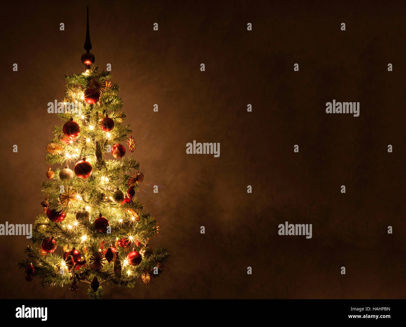 Decorated and lit Christmas tree on plain background Stock Photo - Alamy
