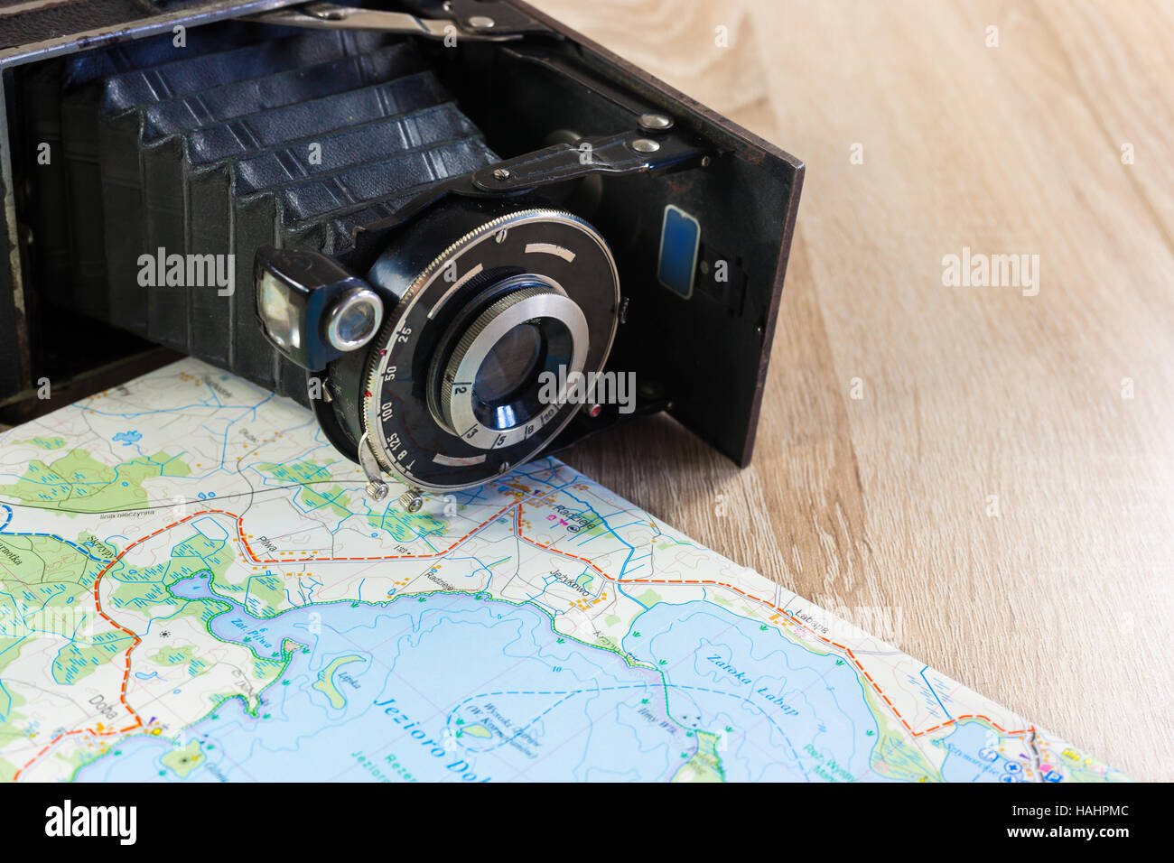 Old folded Leica camera with prontor lens on a map of lakes in Poland ...