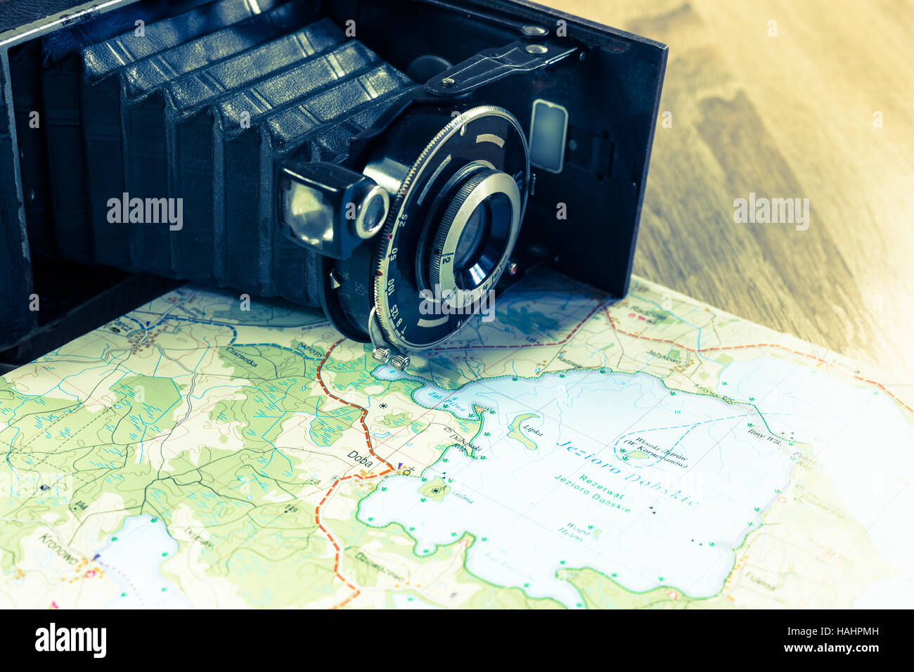 Old folded Leica camera with prontor lens on a map of lakes in Poland ...