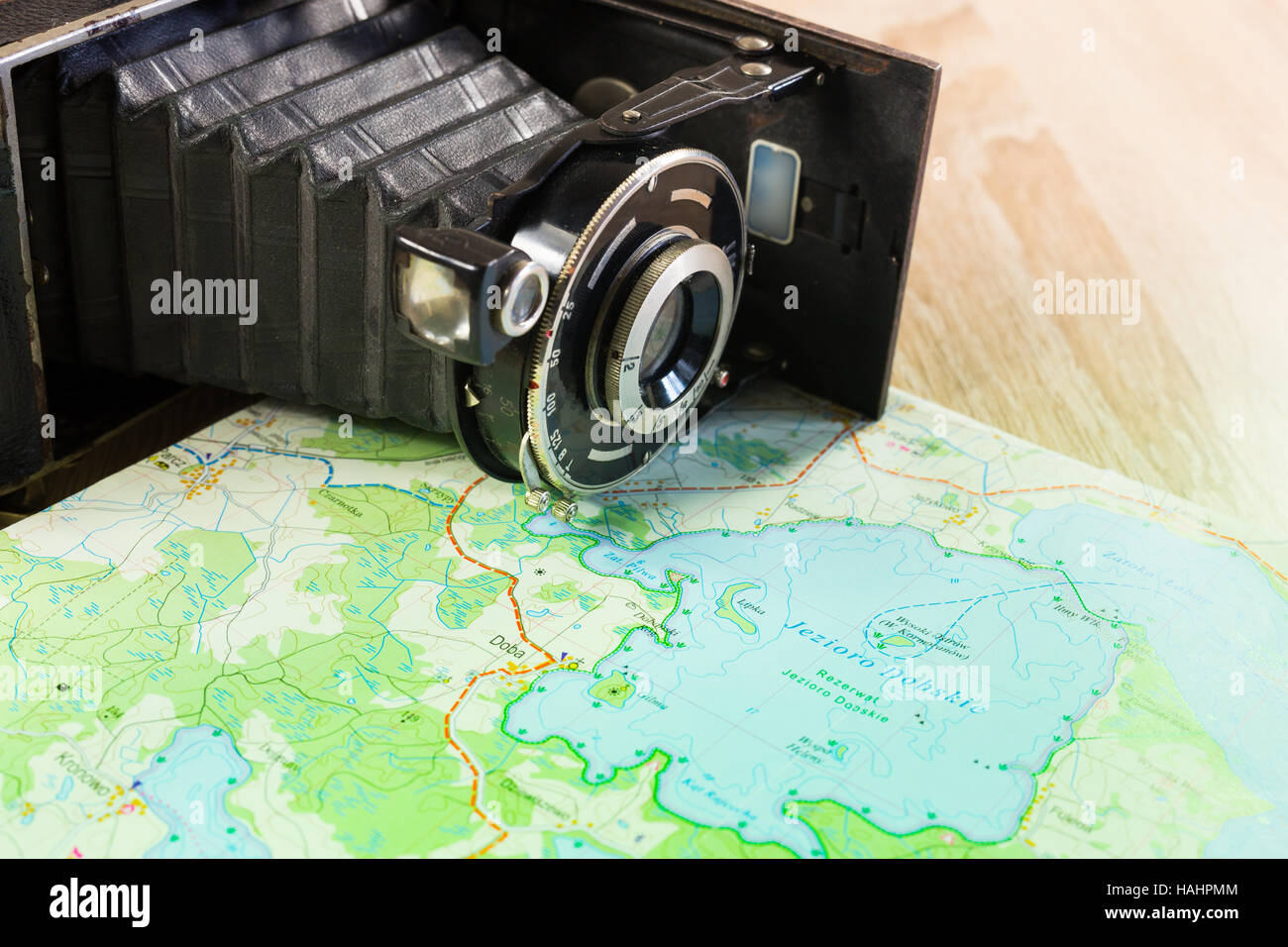 Old folded Leica camera with prontor lens on a map of lakes in Poland ...