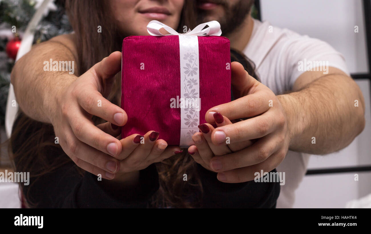 Hands of couple giving a red Christmas gift Stock Photo - Alamy