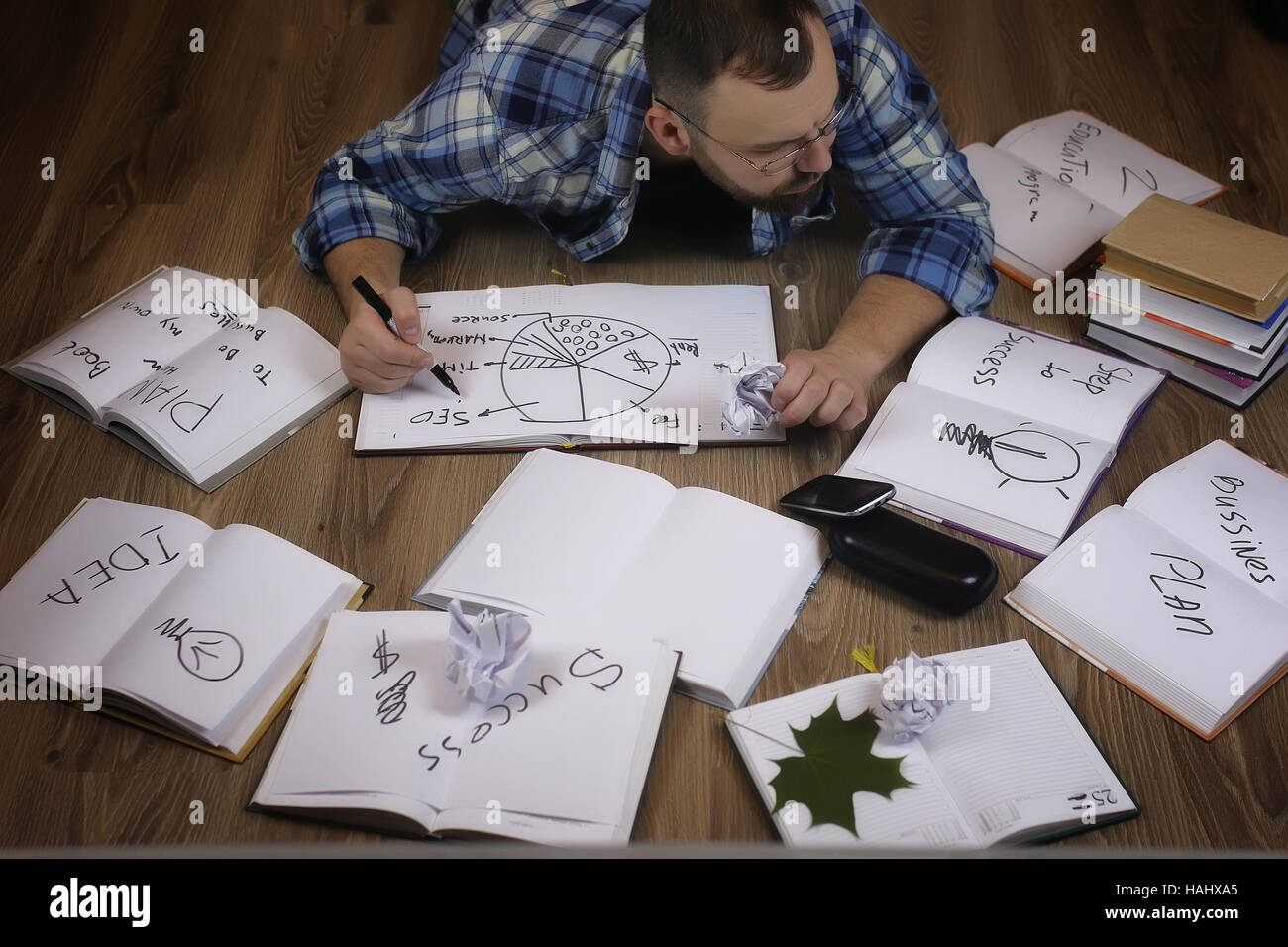 man working with book on the floor Stock Photo - Alamy