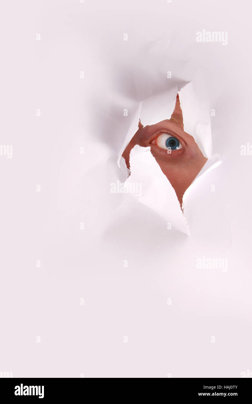 Eye looking through paper hole Stock Photo - Alamy