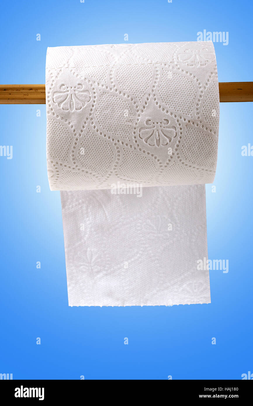 toilet paper roll hanging on blue background Stock Photo - Alamy