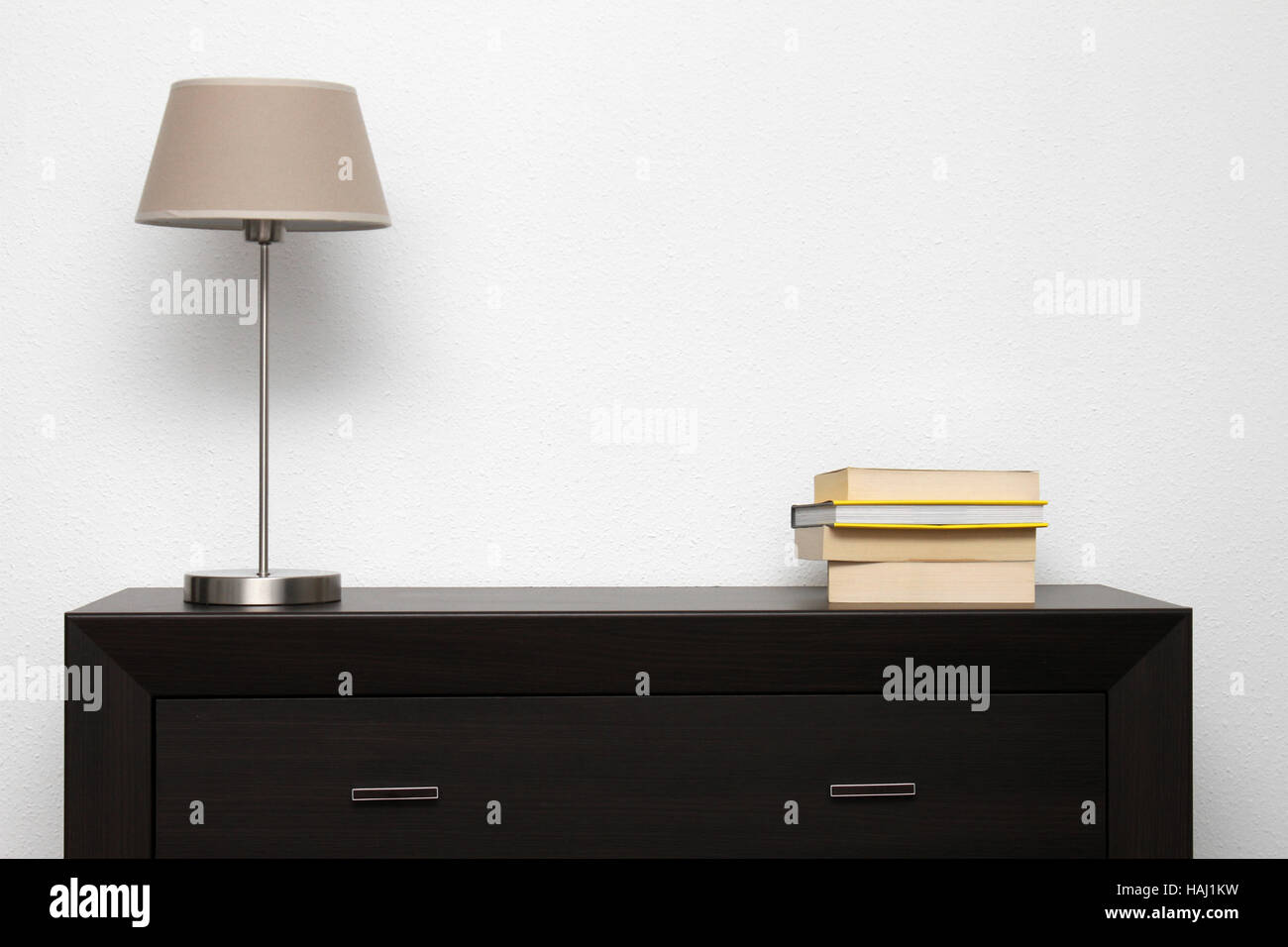 brown commode with lamp and books in bright minimalism interior Stock ...
