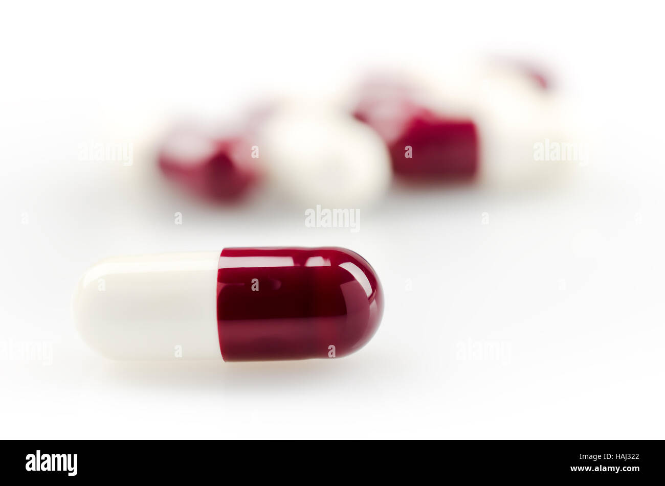 Medical theme. Dark red capsules on a white surface. Closeup Stock ...