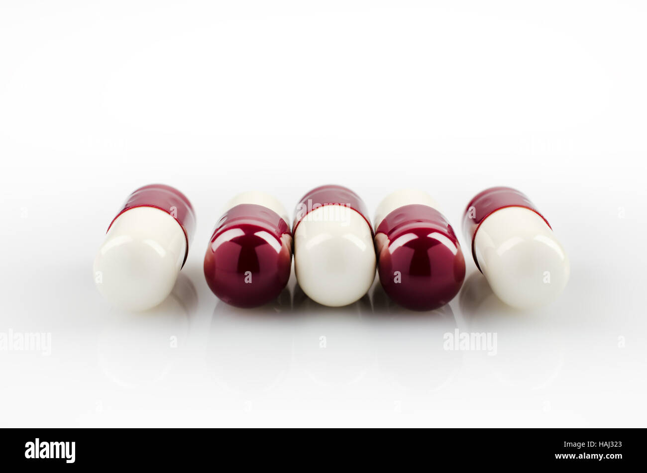 Medical theme. Dark red capsules on a white surface. Closeup Stock ...
